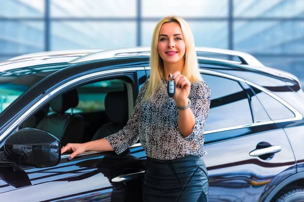 Business woman driver holding auto keys in front of car - Stock Image ...