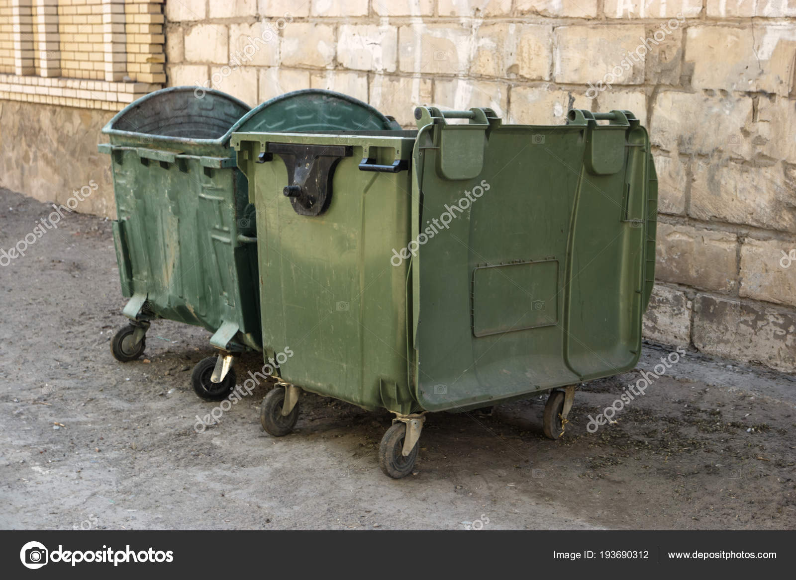 Two Green Trash Dumpsters In Front Of White Brick Wall Angle View ...