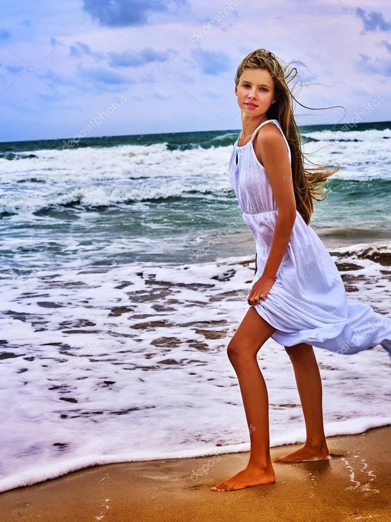 Mujer en la playa al atardecer escribiendo amor en la arena. 2022