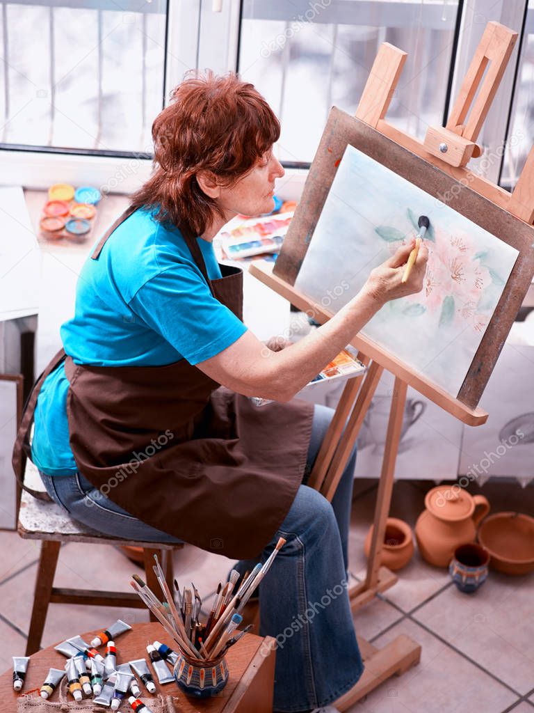 Artista pintando caballete en el estudio. Auténtica mujer mayor. 2024