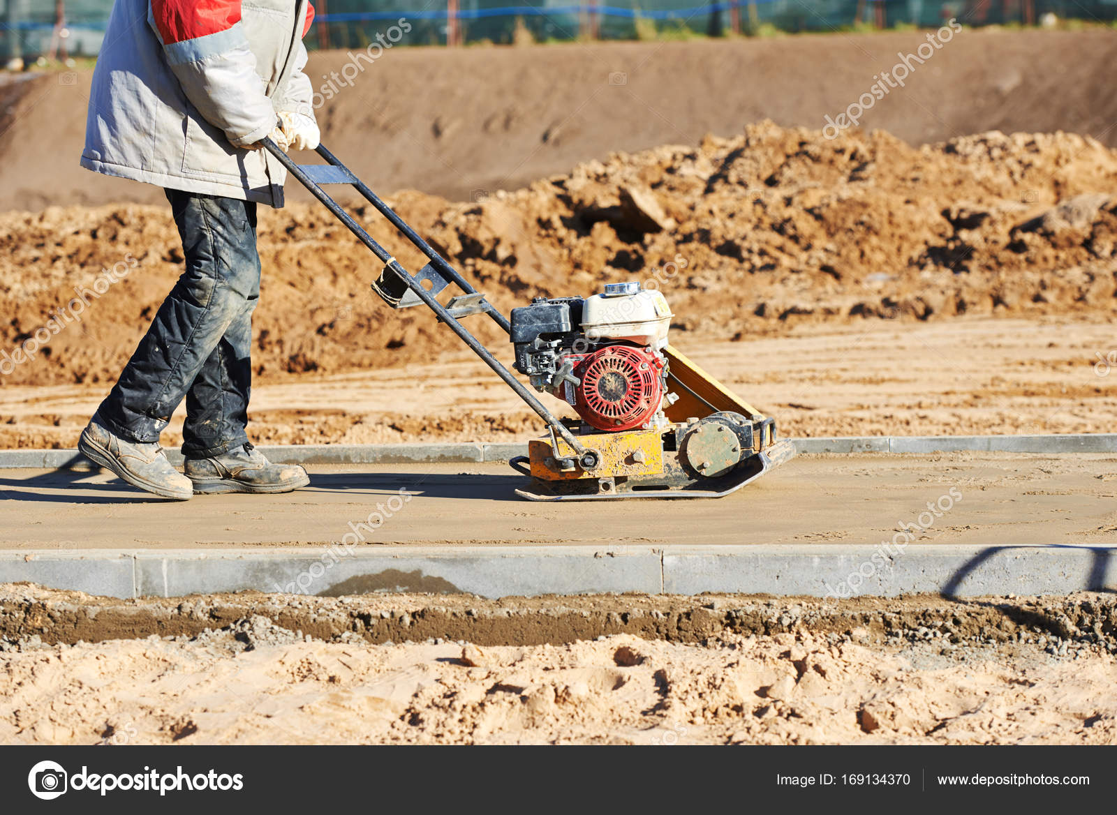 Worker with vibration compactor Stock Photo by ©kalinovsky 169134370