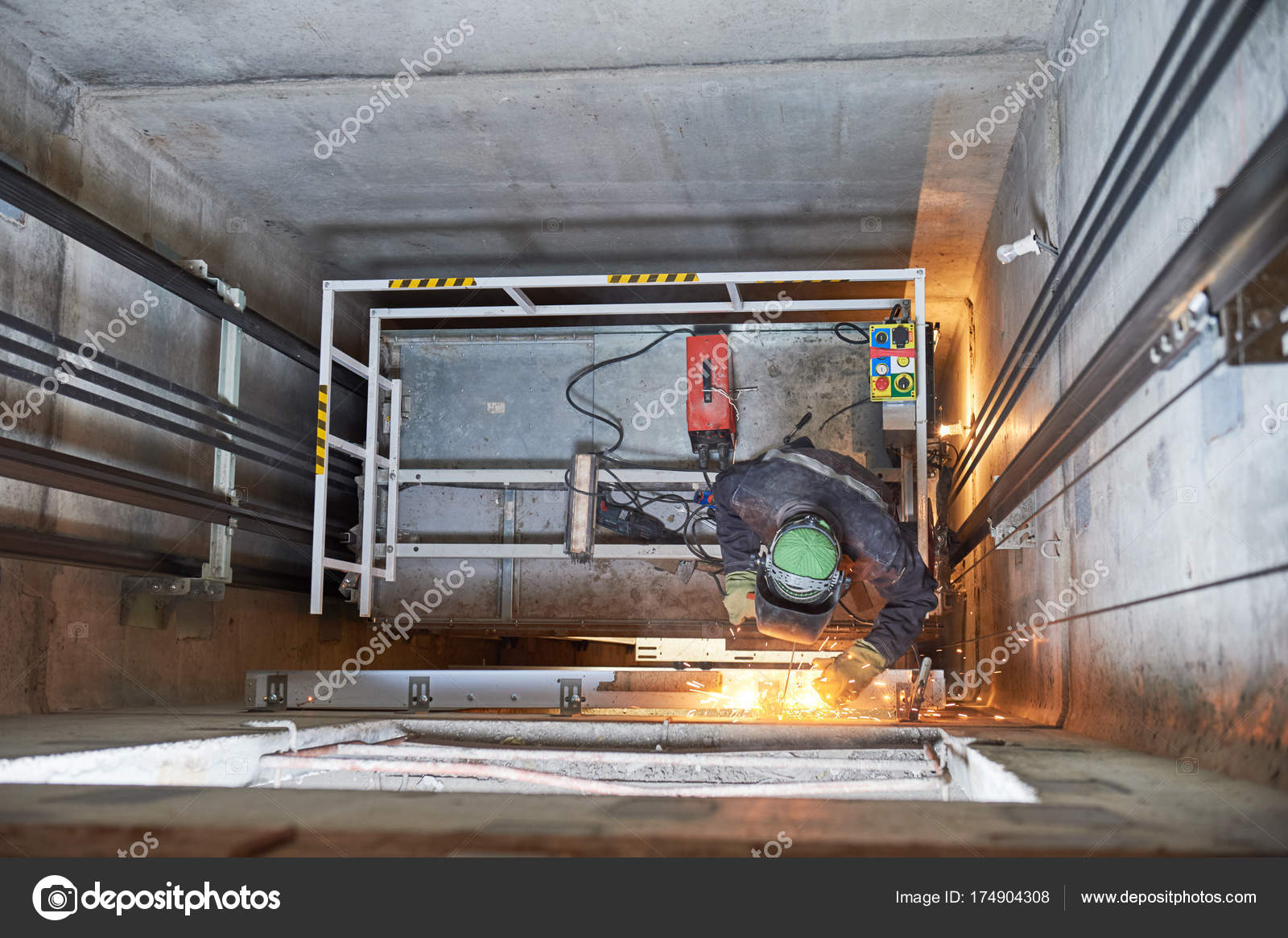 Mengangkat pekerja pengelasan pengikat lift dalam poros angkat — Foto ...