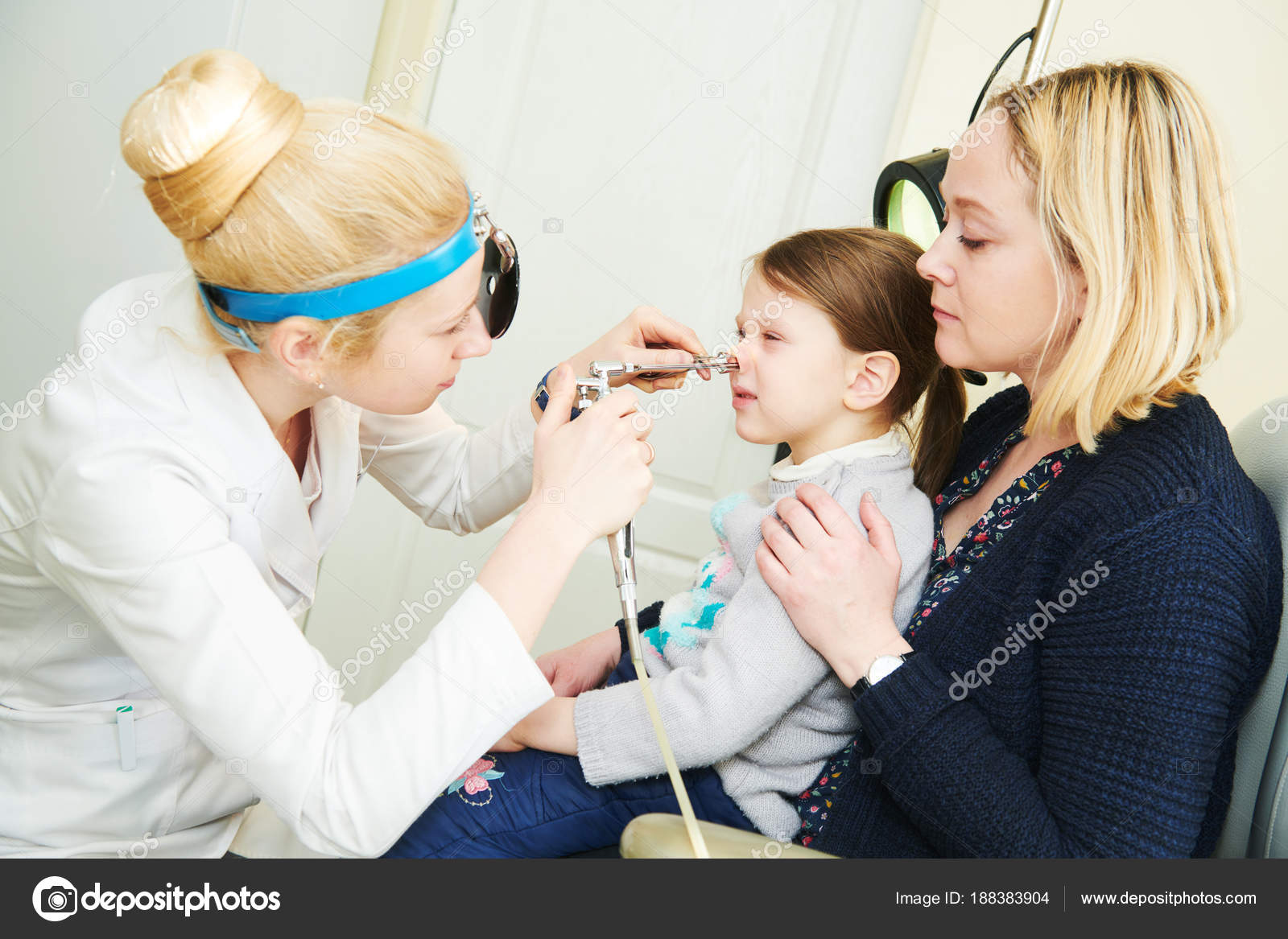 Female doctor of ENT ear nose throat at work examining girl nose ...