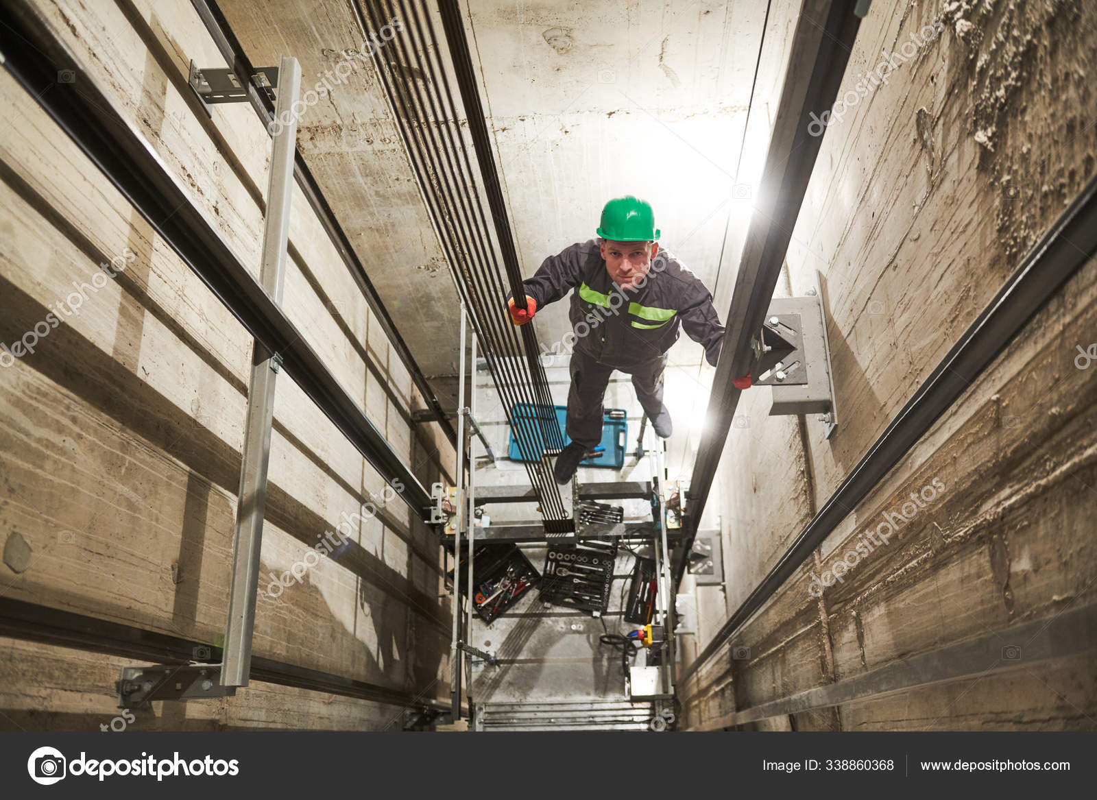Lift machinist repairing elevator in lift shaft Stock Photo by ...