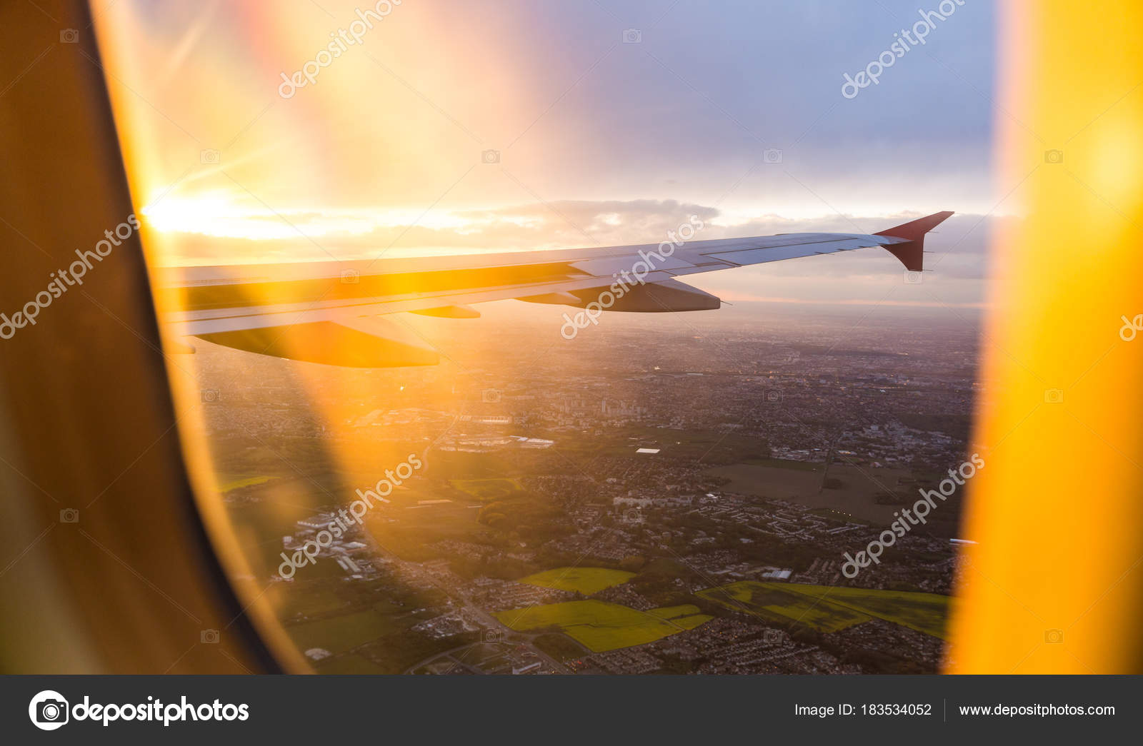 Sunset aerial view through airplane window over wing Stock Photo by ...
