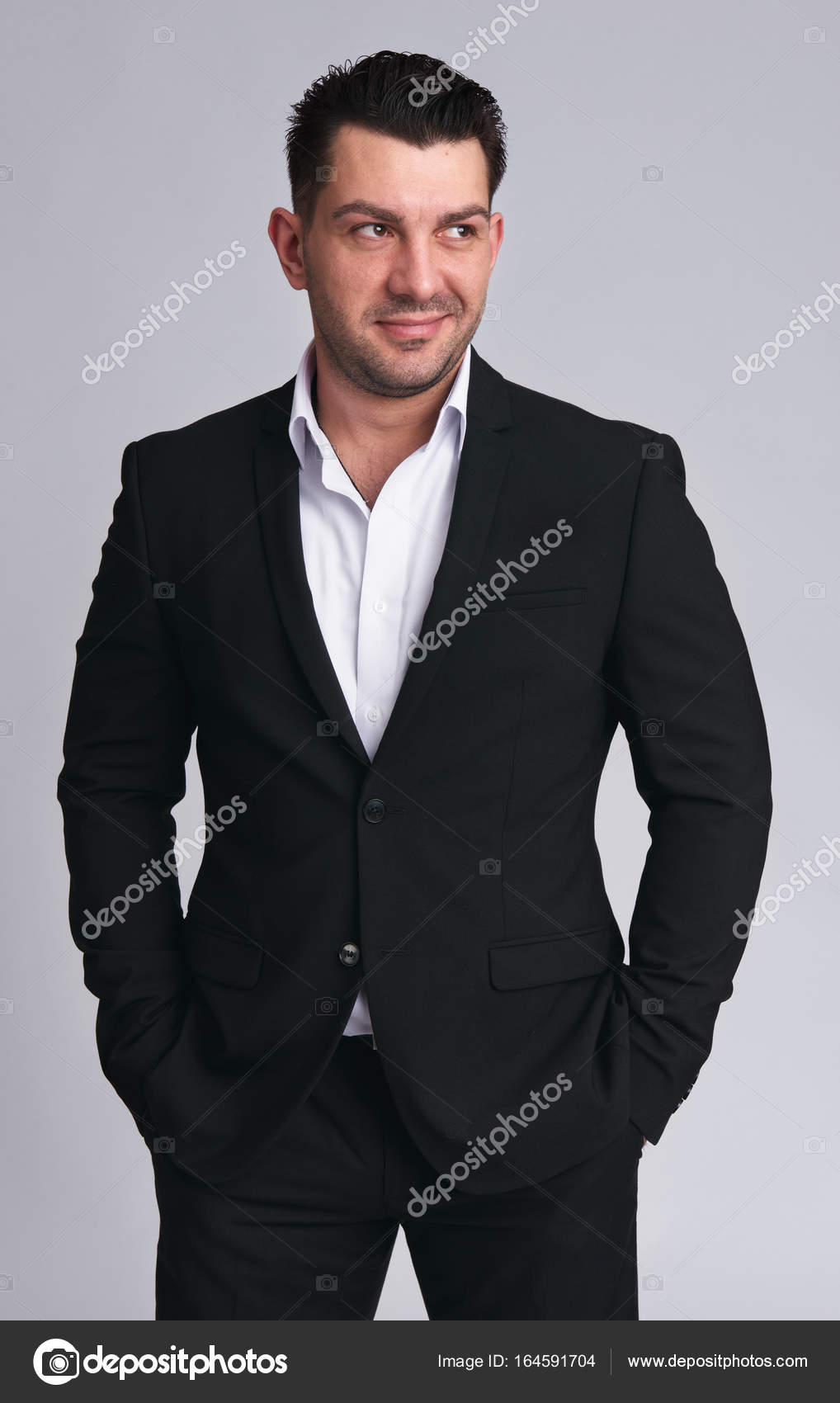 Handsome man in black suit smirking Stock Photo by ©spaxiax 164591704