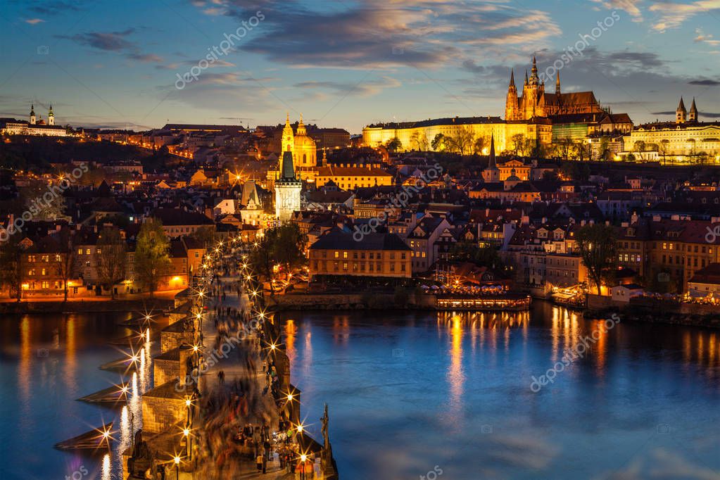Vista nocturna del castillo de Praga y el puente de Carlos sobre el río ...