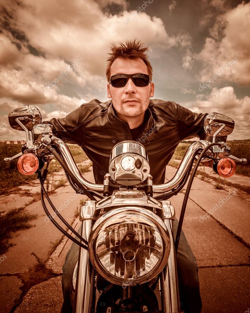 Biker in a leather jacket riding a motorcycle on the road — Stock Photo ...