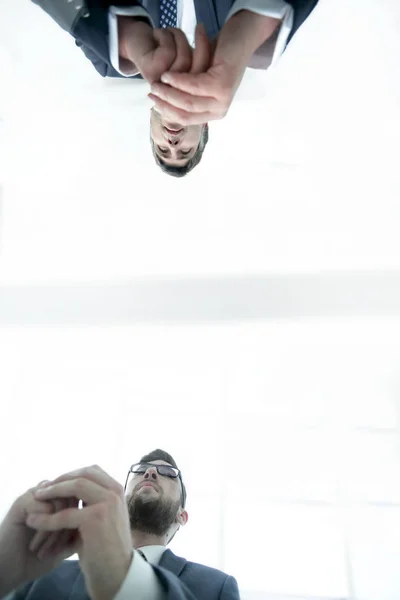 View from below. From behind the glass. Two businessmen sitting at the ...