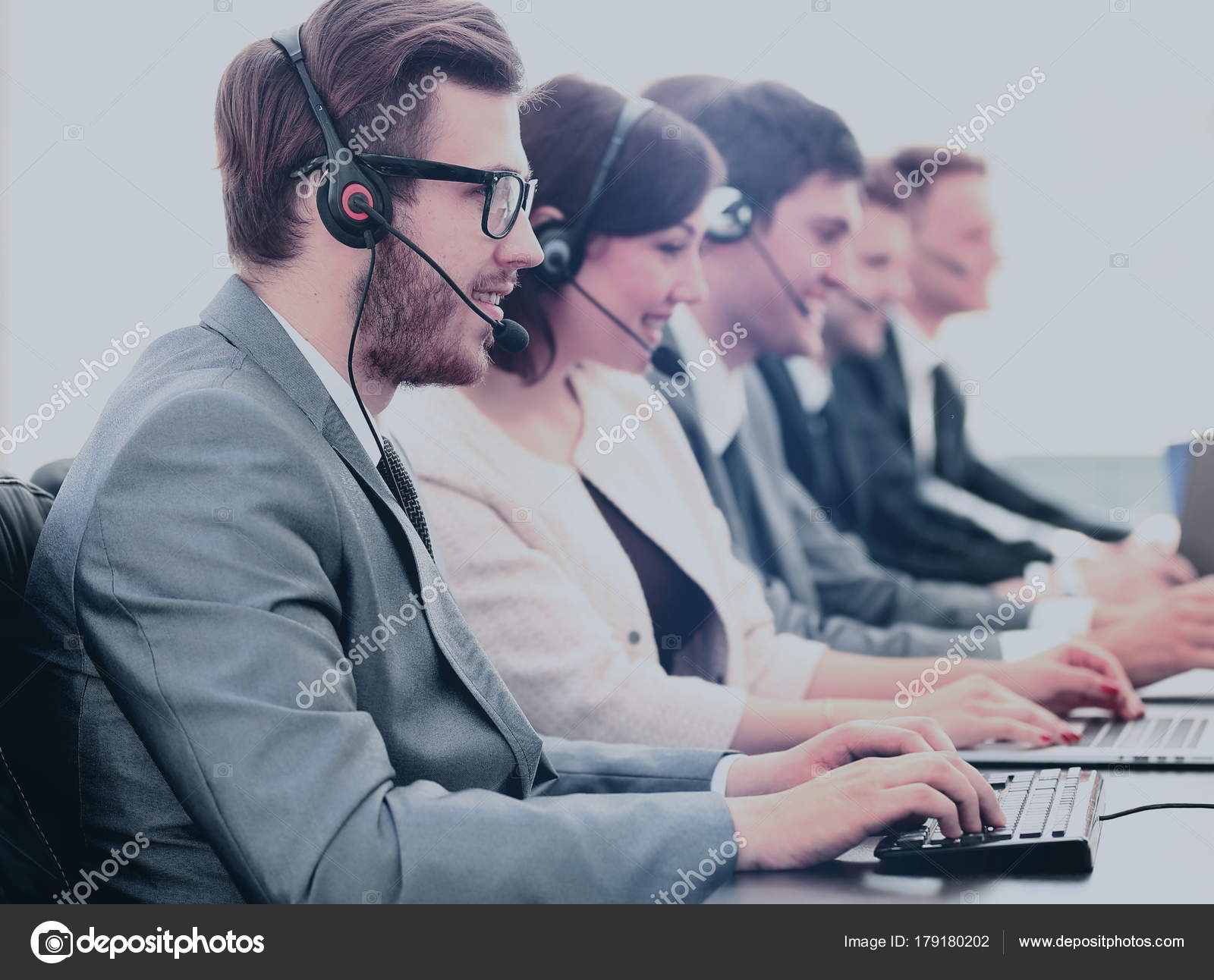 Jovem atraente trabalhando em um call center com seus colegas fotos ...