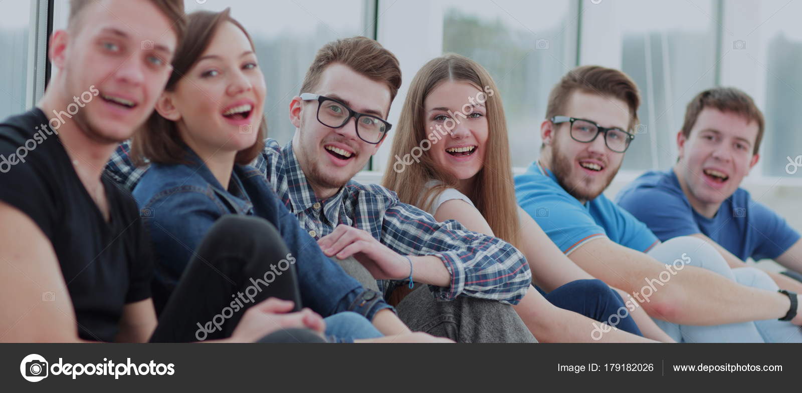 A group of happy students sitting on a window sill and smiling — Stock ...
