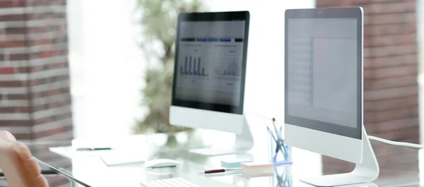 Close-up of the screens of personal computers on a modern workplace in ...