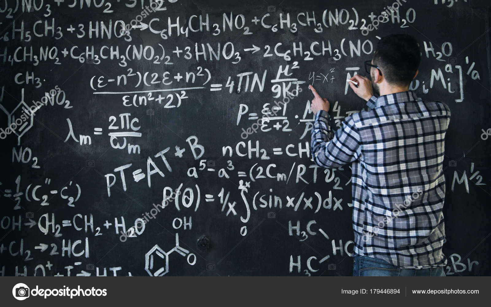 Young scientist man write chock in chemical and mathematical equations ...