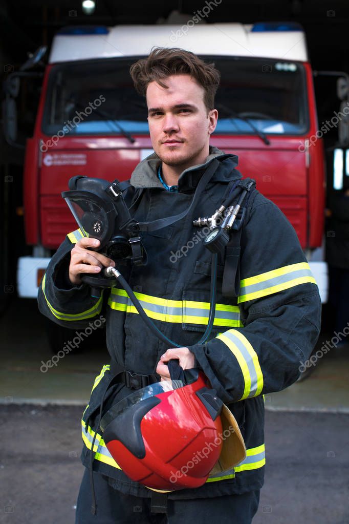 Retrato de cerca de un joven bombero en el fondo de un cami n de bomberos 2024