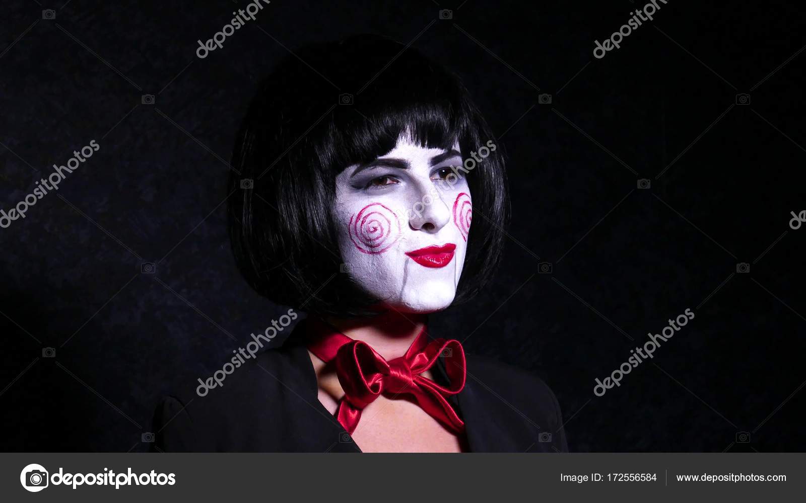 Pretty woman in horror style make up sings a song on dark background ...