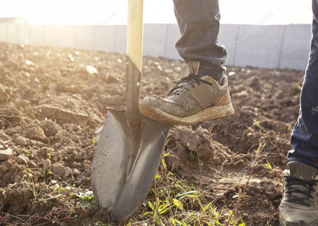 El hombre está cavando el suelo en su casa de campo 2023