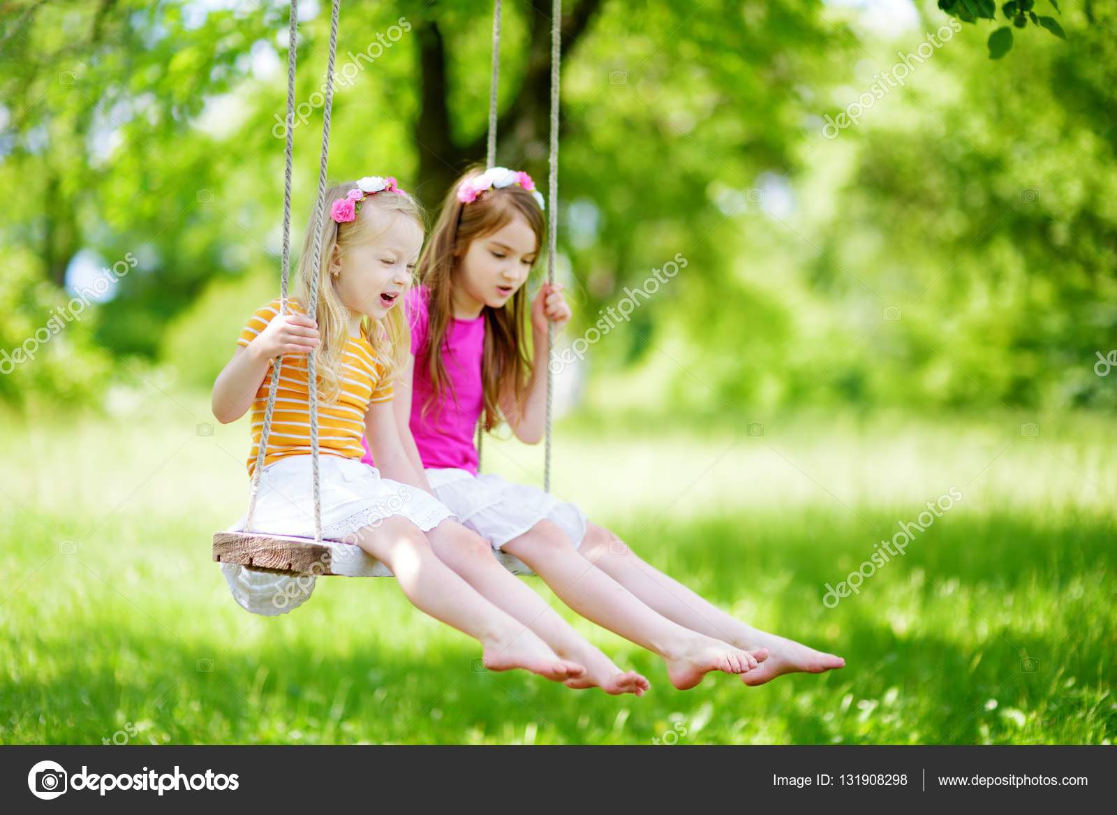Two little sisters on a swing Stock Photo by ©MNStudio 131908298