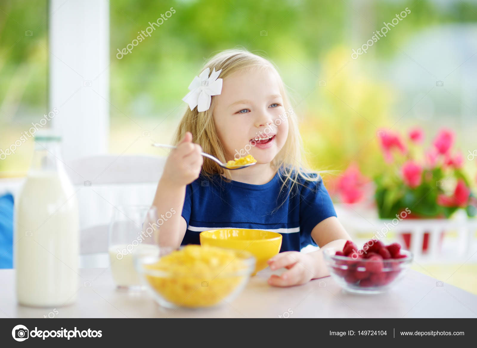 Pretty child eating corn flakes Stock Photo by ©MNStudio 149724104