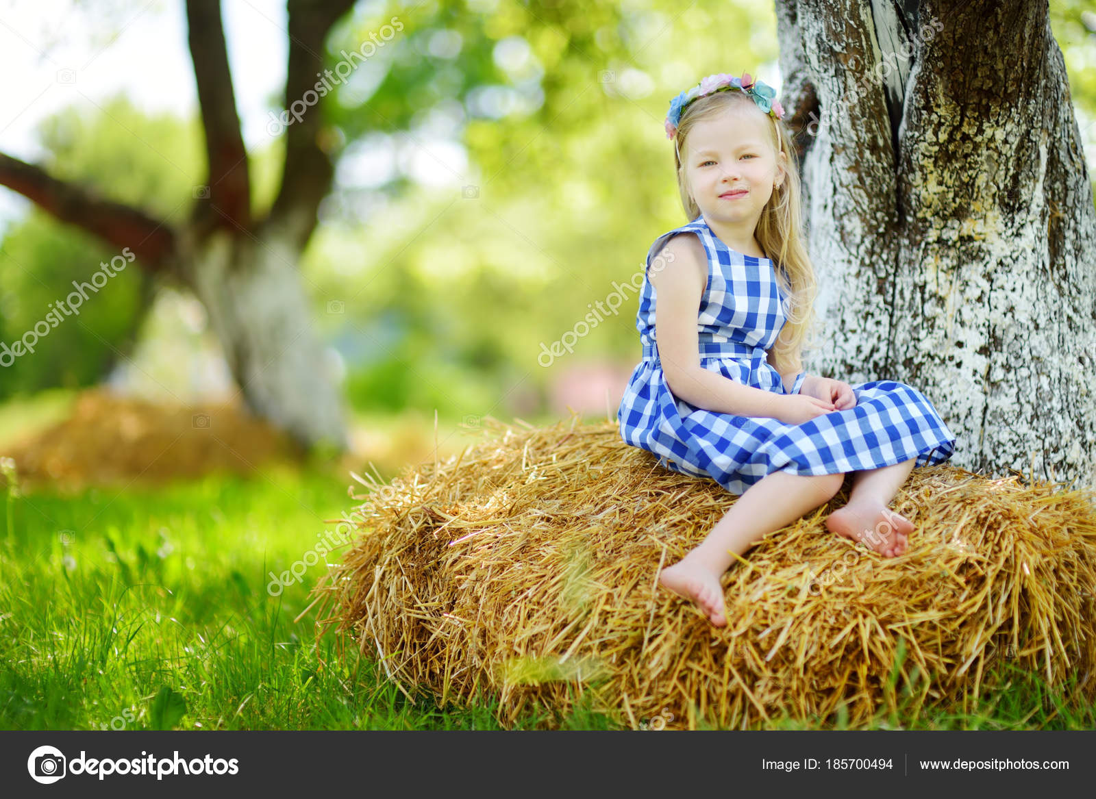 Little girl sitting on haystack Stock Photo by ©MNStudio 185700494