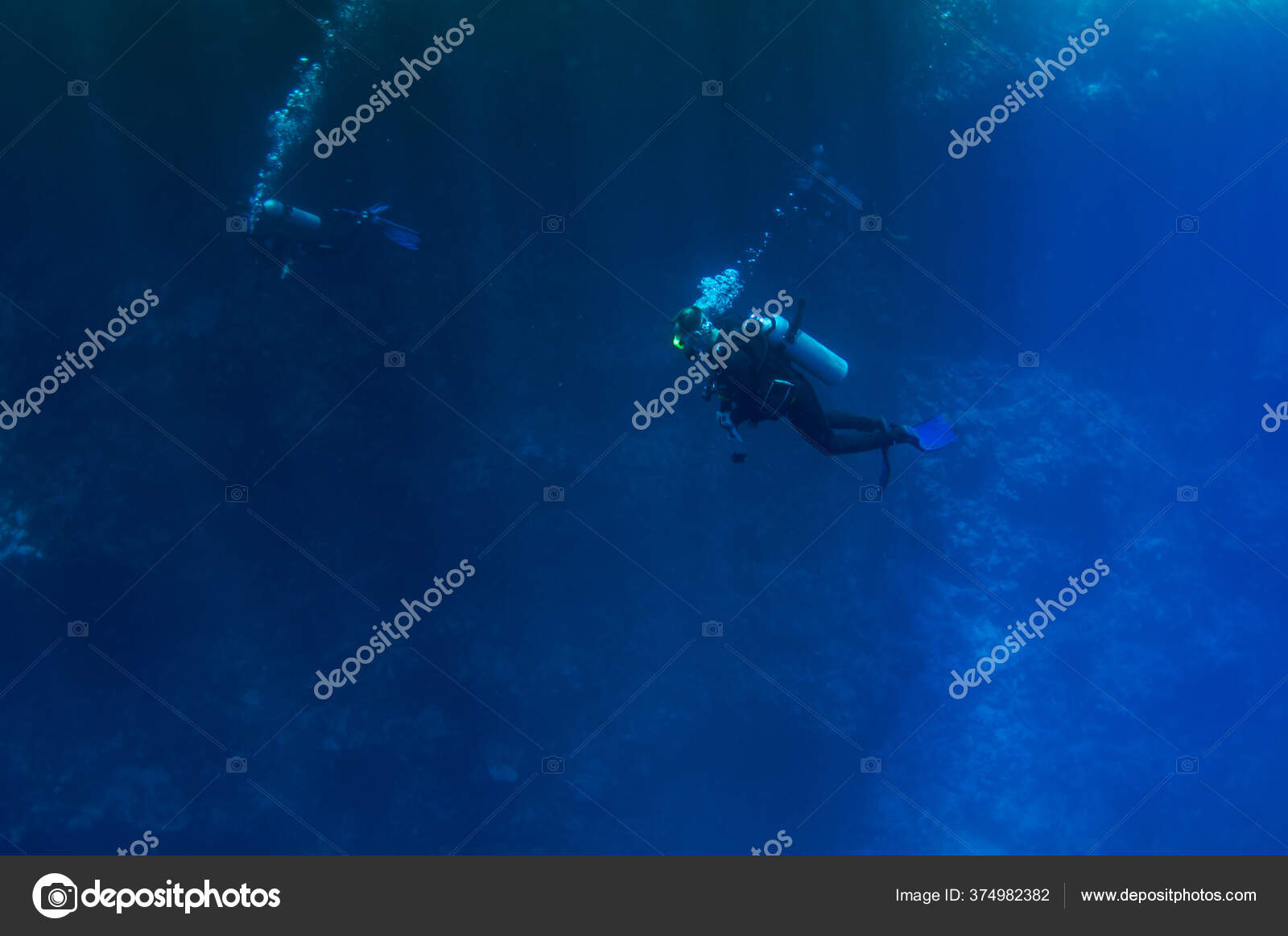 Top view on scuba divers group swimming who exploring deep dark ocean ...