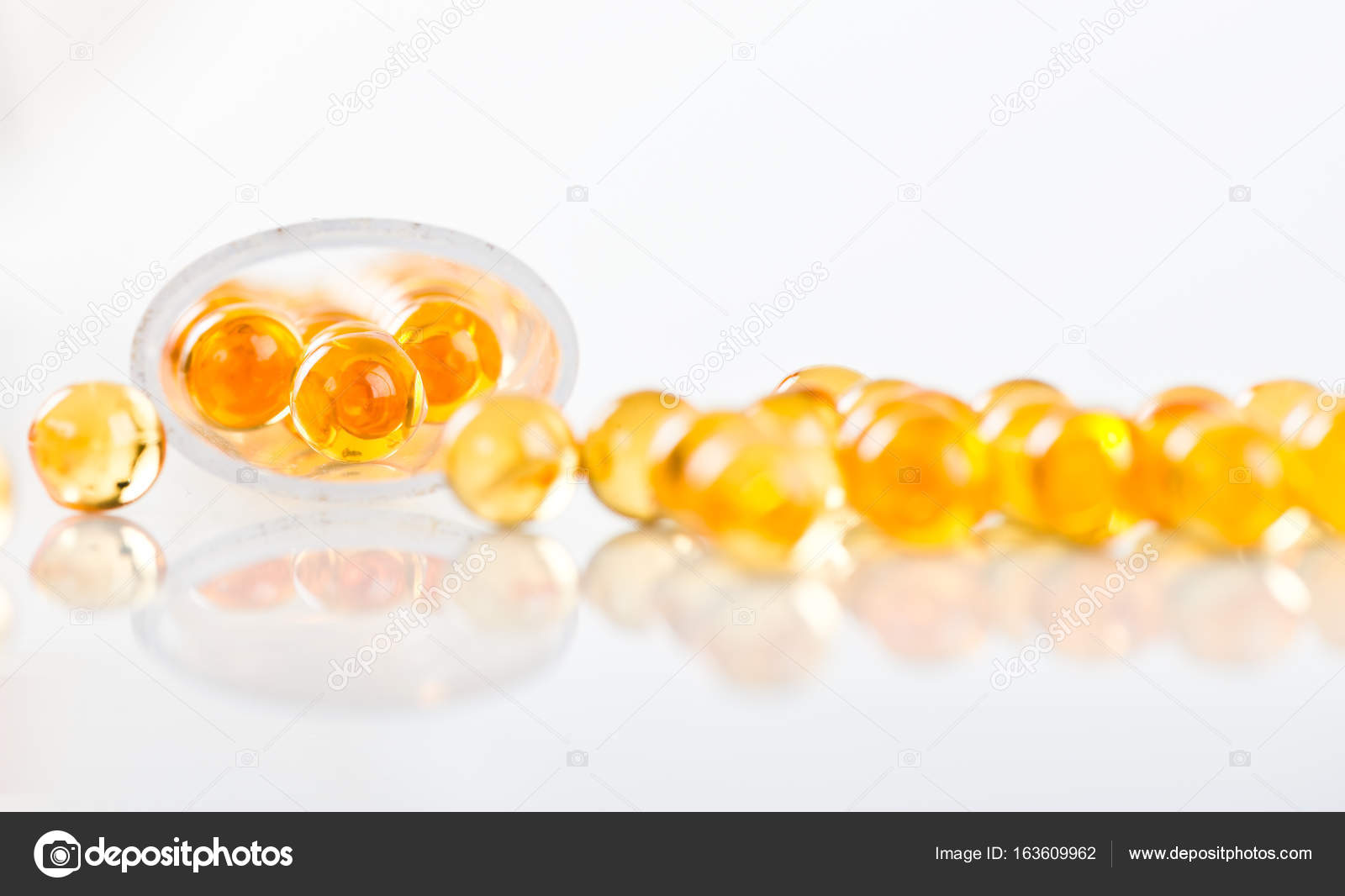 Shiny yellow fish oil capsules Stock Photo by ©valphoto 163609962