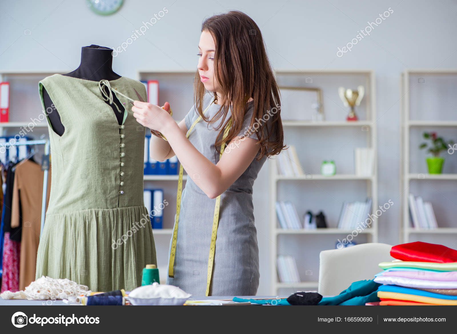 Woman tailor working on a clothing sewing stitching measuring fa ...