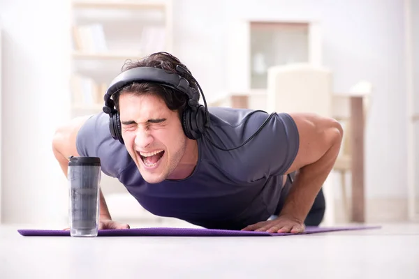 Man doing sports at home and listening to music - Stock Image - Everypixel