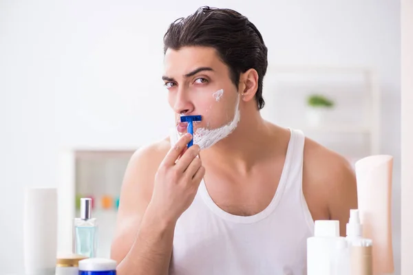 Young handsome man shaving early in the morning at home - Stock Image - Everypixel
