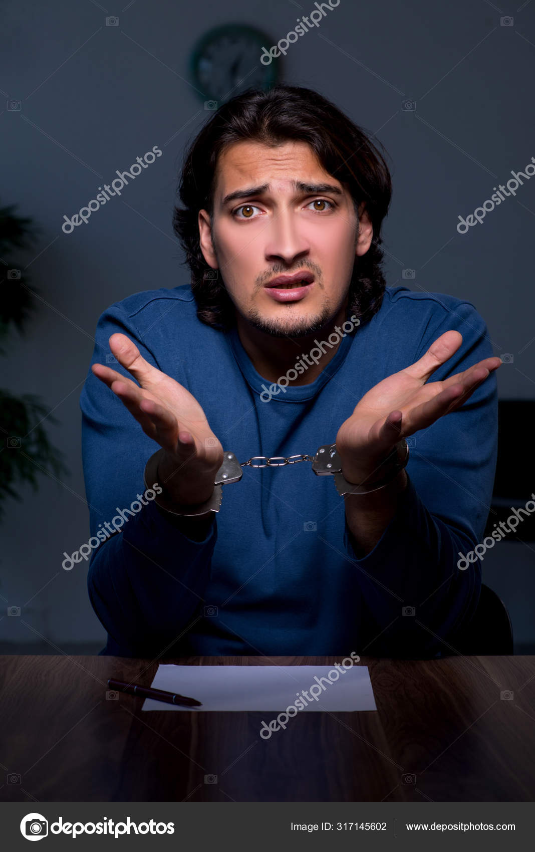 Young convict man sitting in dark room — Stock Photo © Elnur_ #317145602