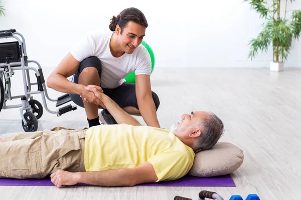 Old injured man doing exercises indoors - Stock Image - Everypixel