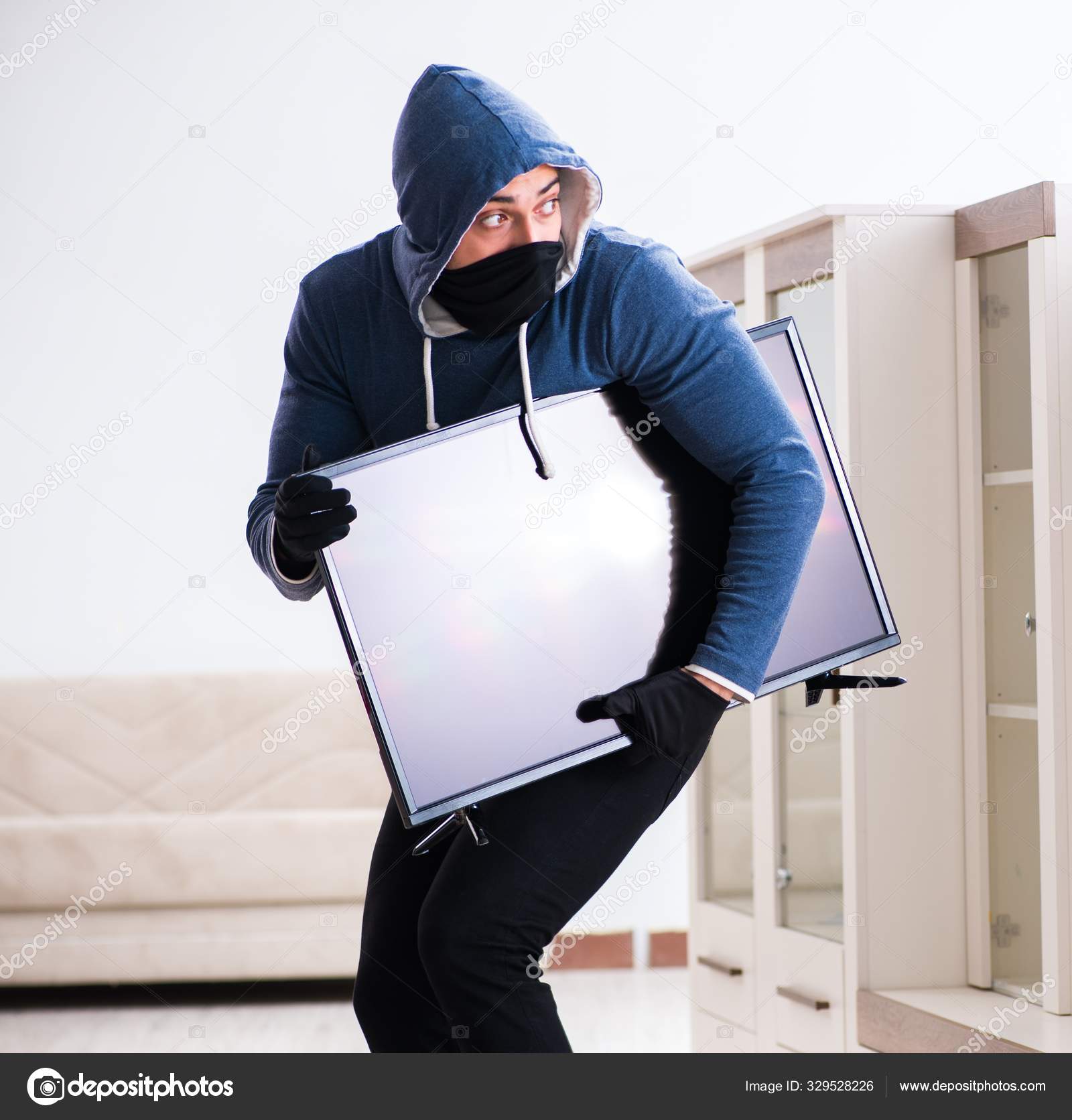 Man burglar stealing tv set from house — Stock Photo © Elnur_ #329528226