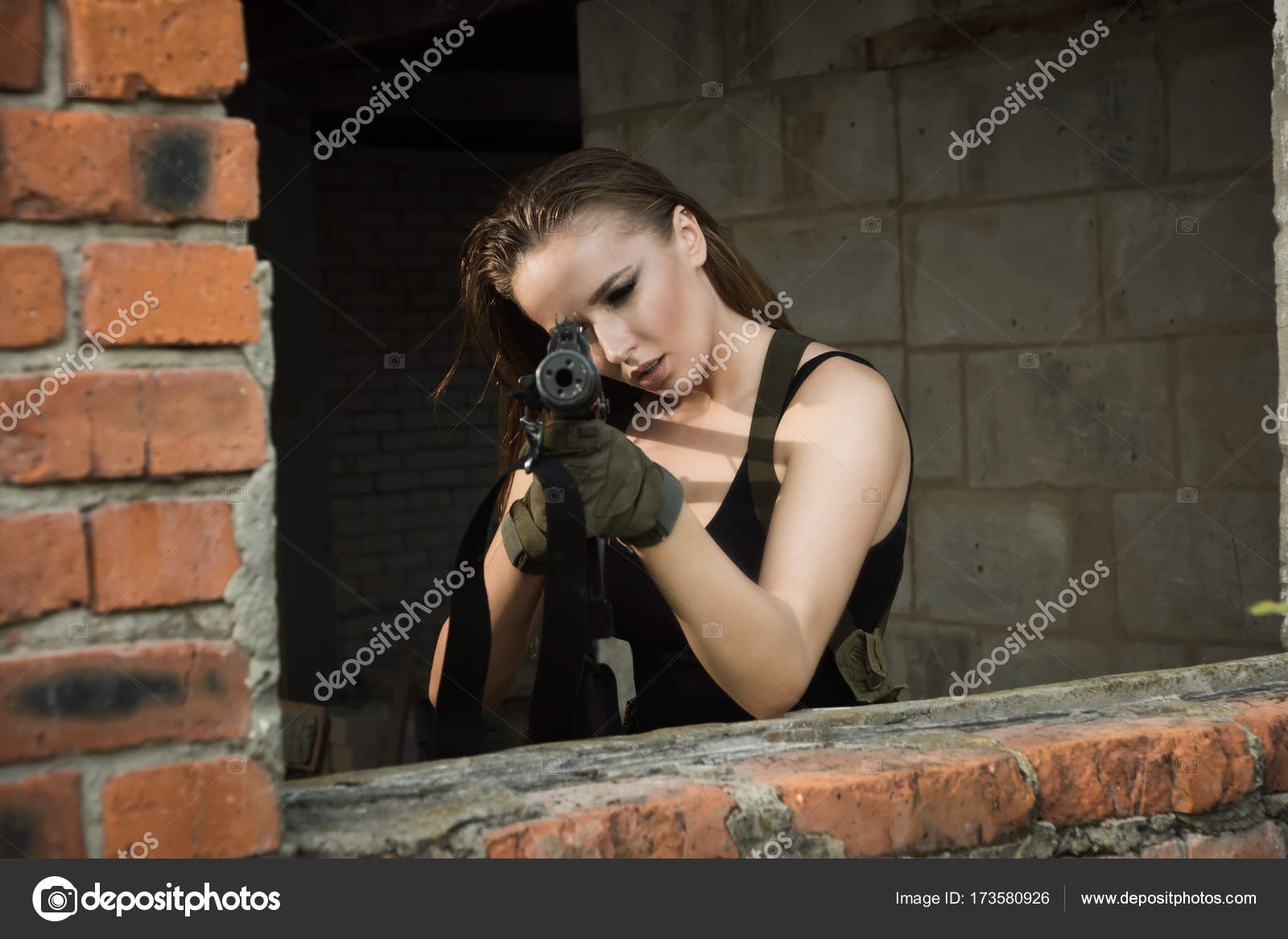 A girl with a submachine gun fires — Stock Photo © Demian #173580926
