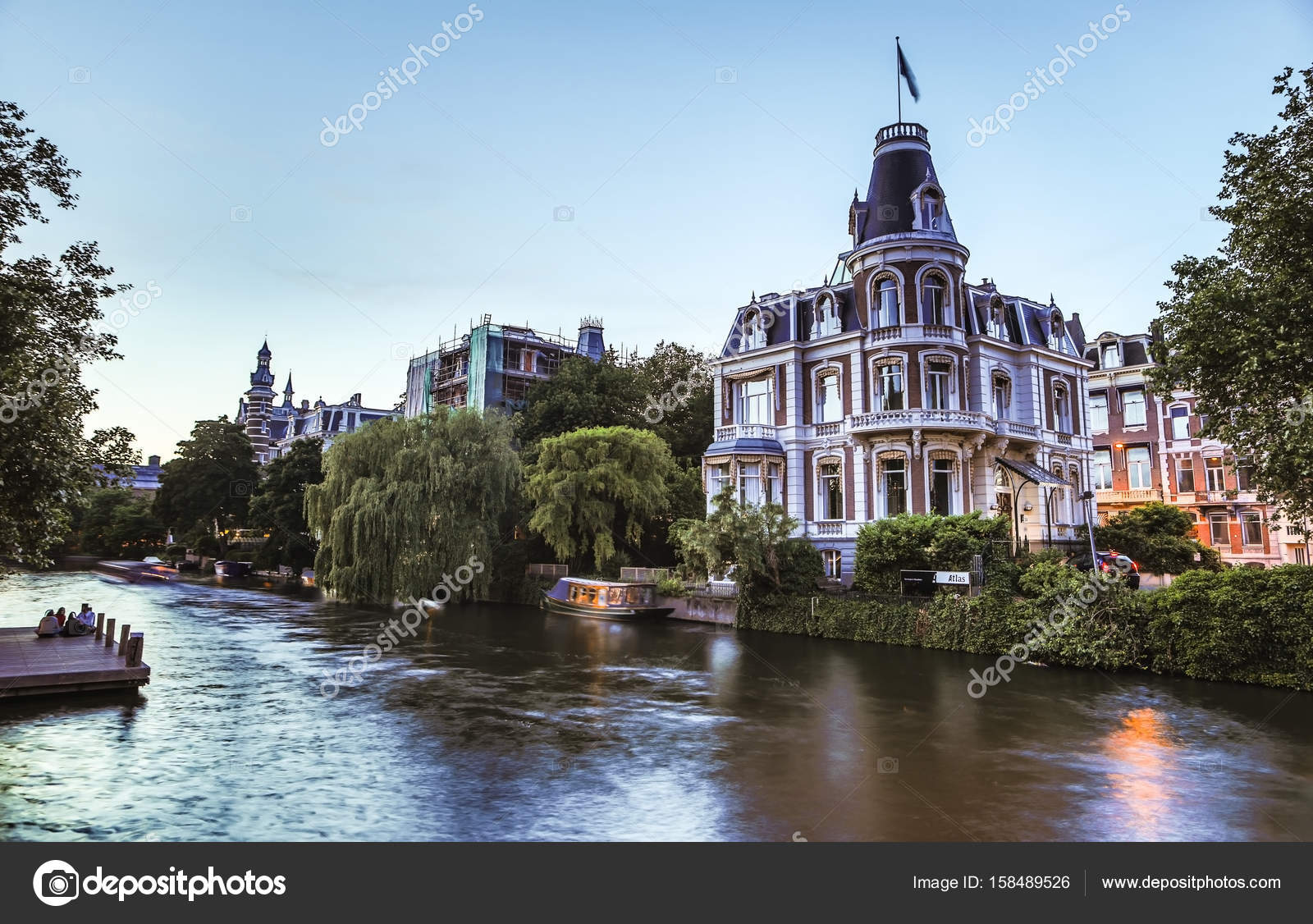 The most famous canals and embankments of Amsterdam city during sunset ...