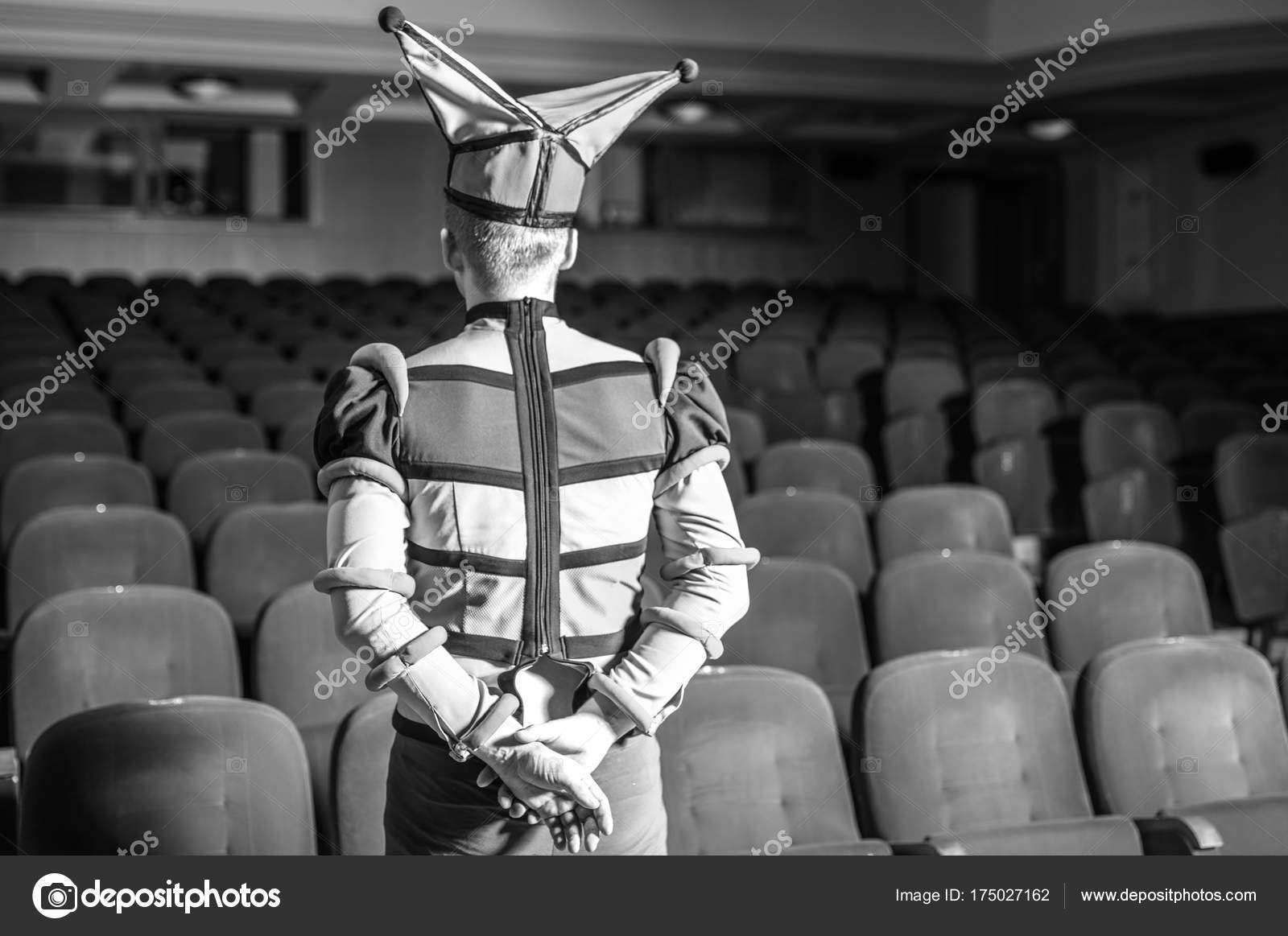 Actor dressed jester's costume in interior of old theater. Black-white ...