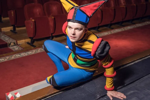 Actor dressed jester's costume in interior of old theater. Black-white ...
