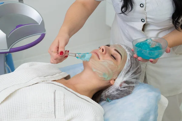 Applying cosmetic gel on the face patient. - Stock Image - Everypixel