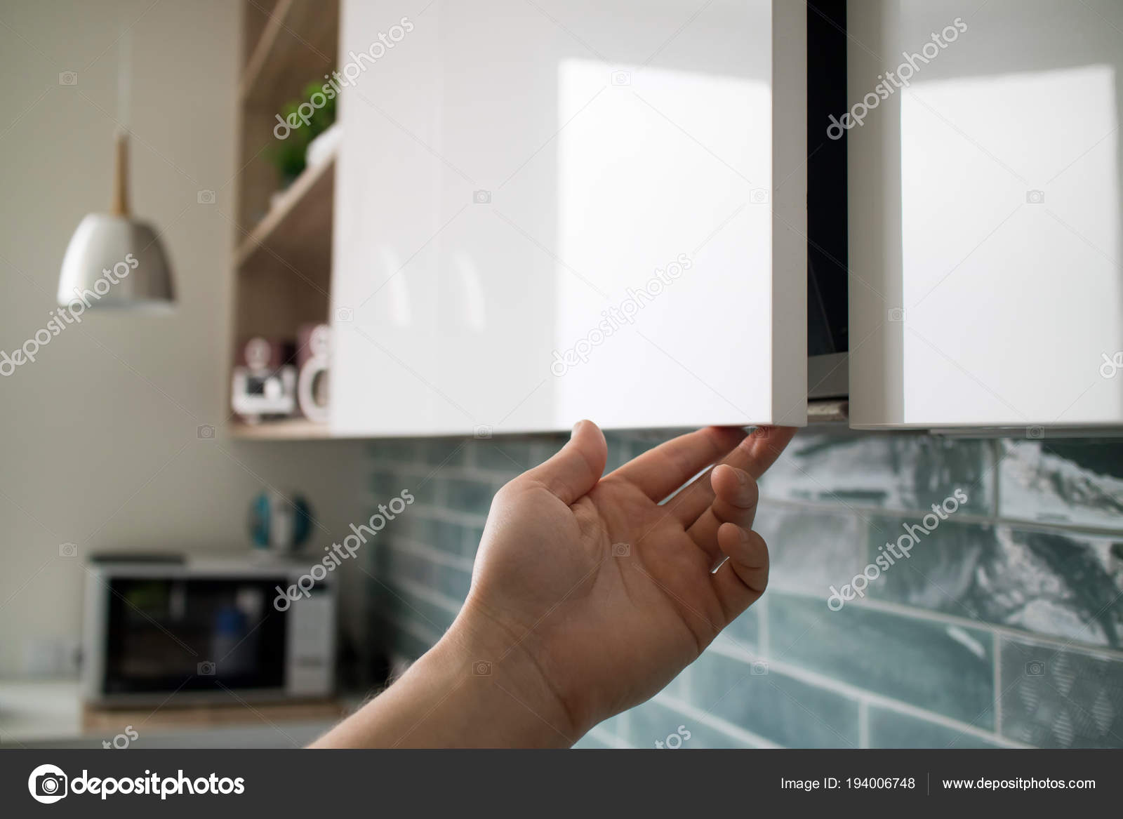 Male Hand Opening Kitchen Cabinet Door Stock Photo by ©artjazz 194006748