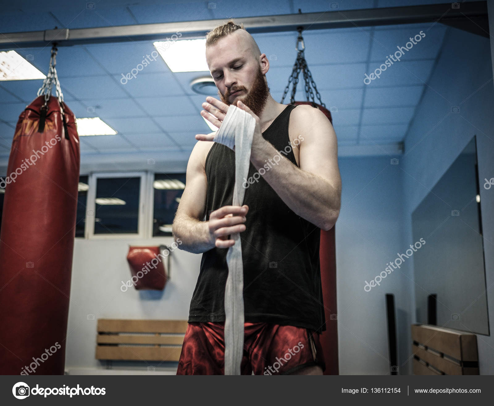 Fighter preparing for training, wrapping hands with boxing wraps ...