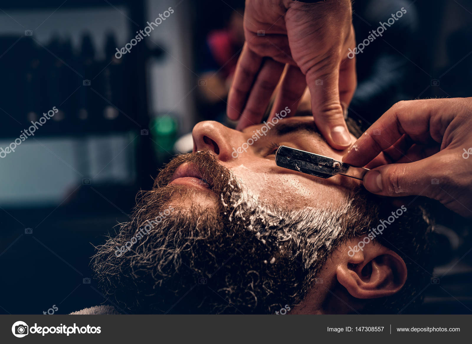 Barber shaving bearded male with a sharp razor — Stock Photo © fxquadro ...