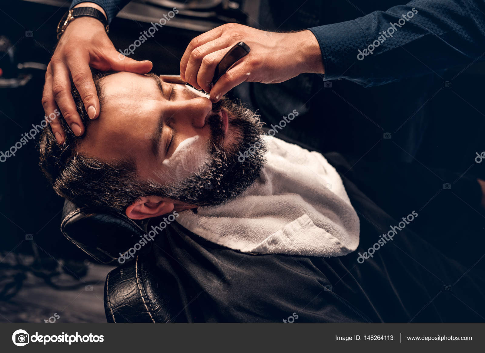 Barber shaving a man with a sharp razor — Stock Photo © fxquadro #148264113
