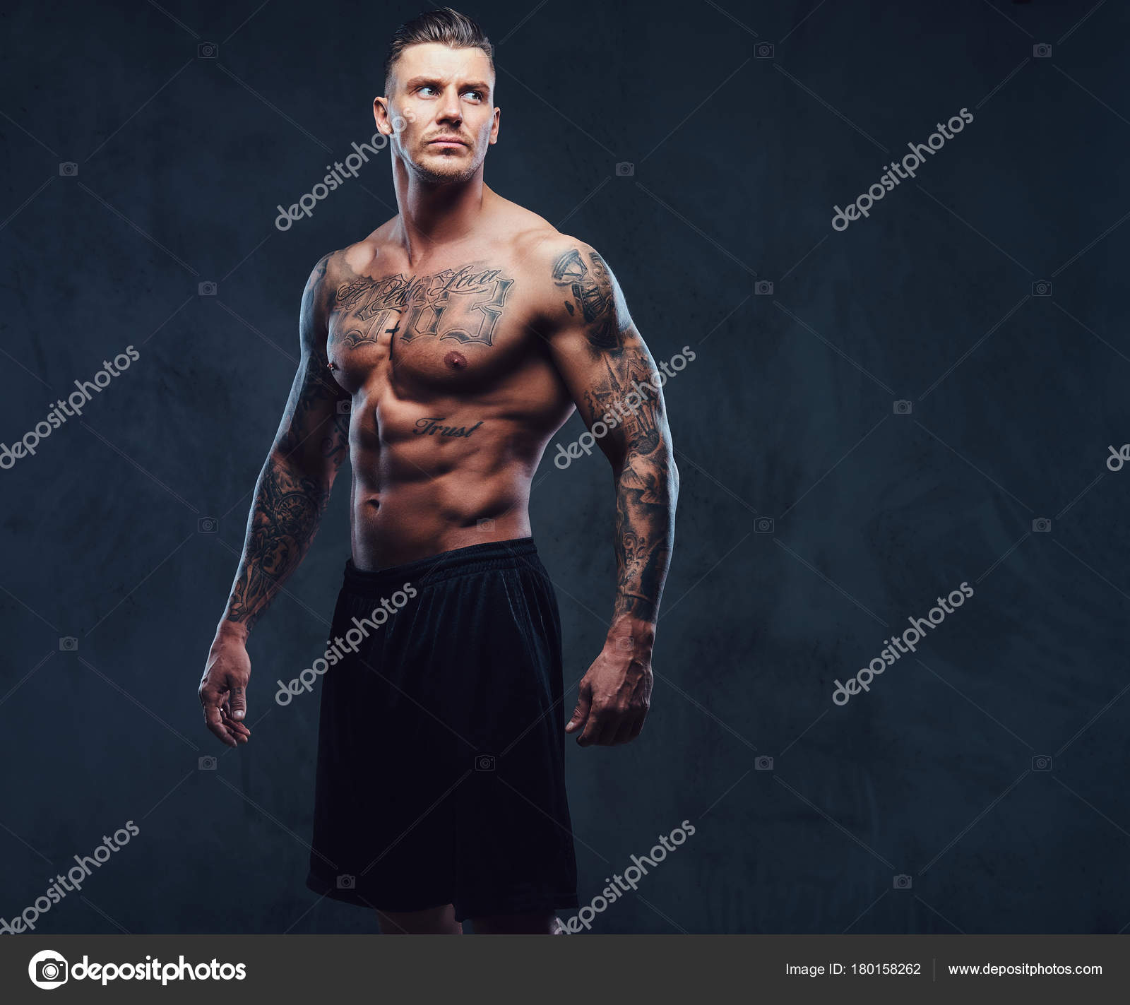 A muscular tattooed man on a dark background. Stock Photo by ©fxquadro ...