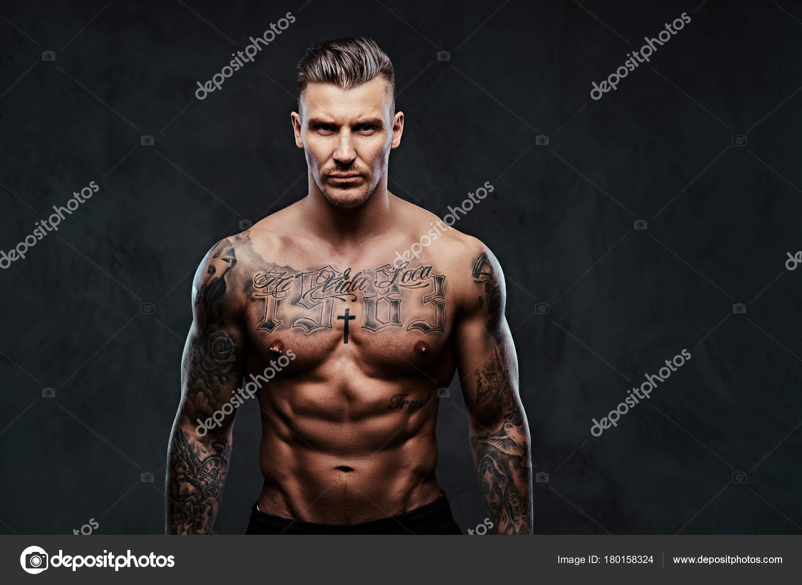 A muscular tattooed man on a dark background. — Stock Photo © fxquadro ...