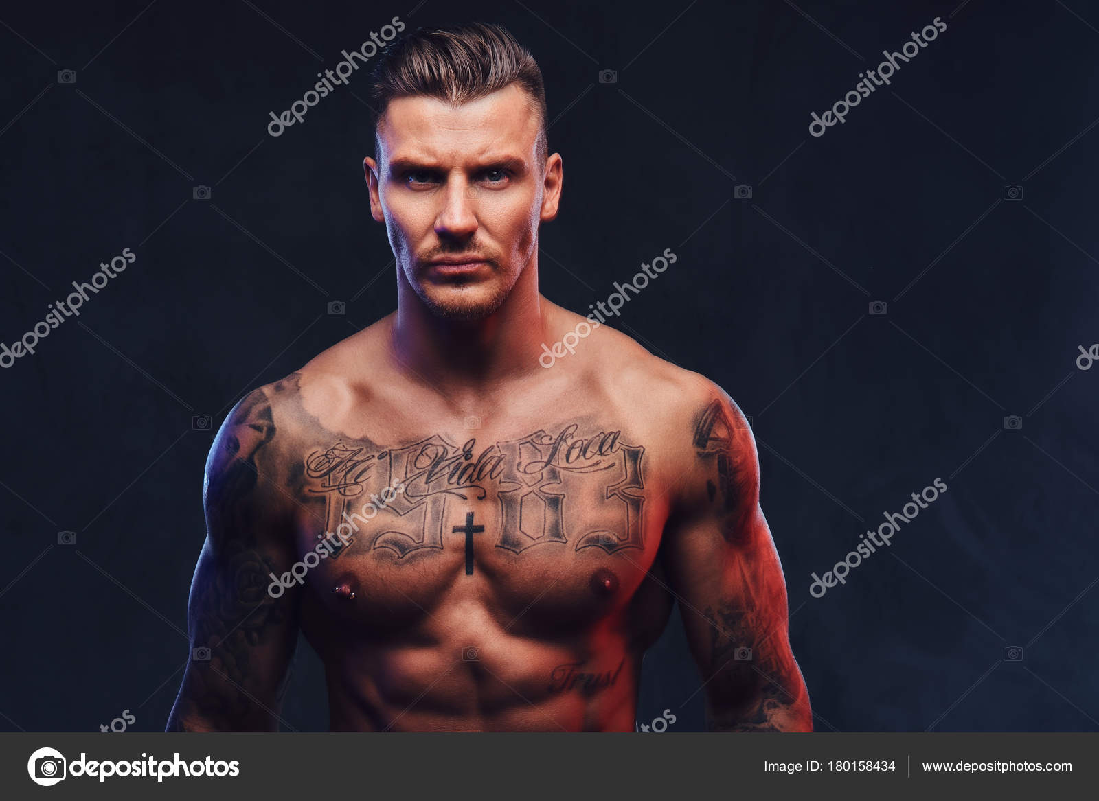 A muscular tattooed man on a dark background. — Stock Photo © fxquadro ...