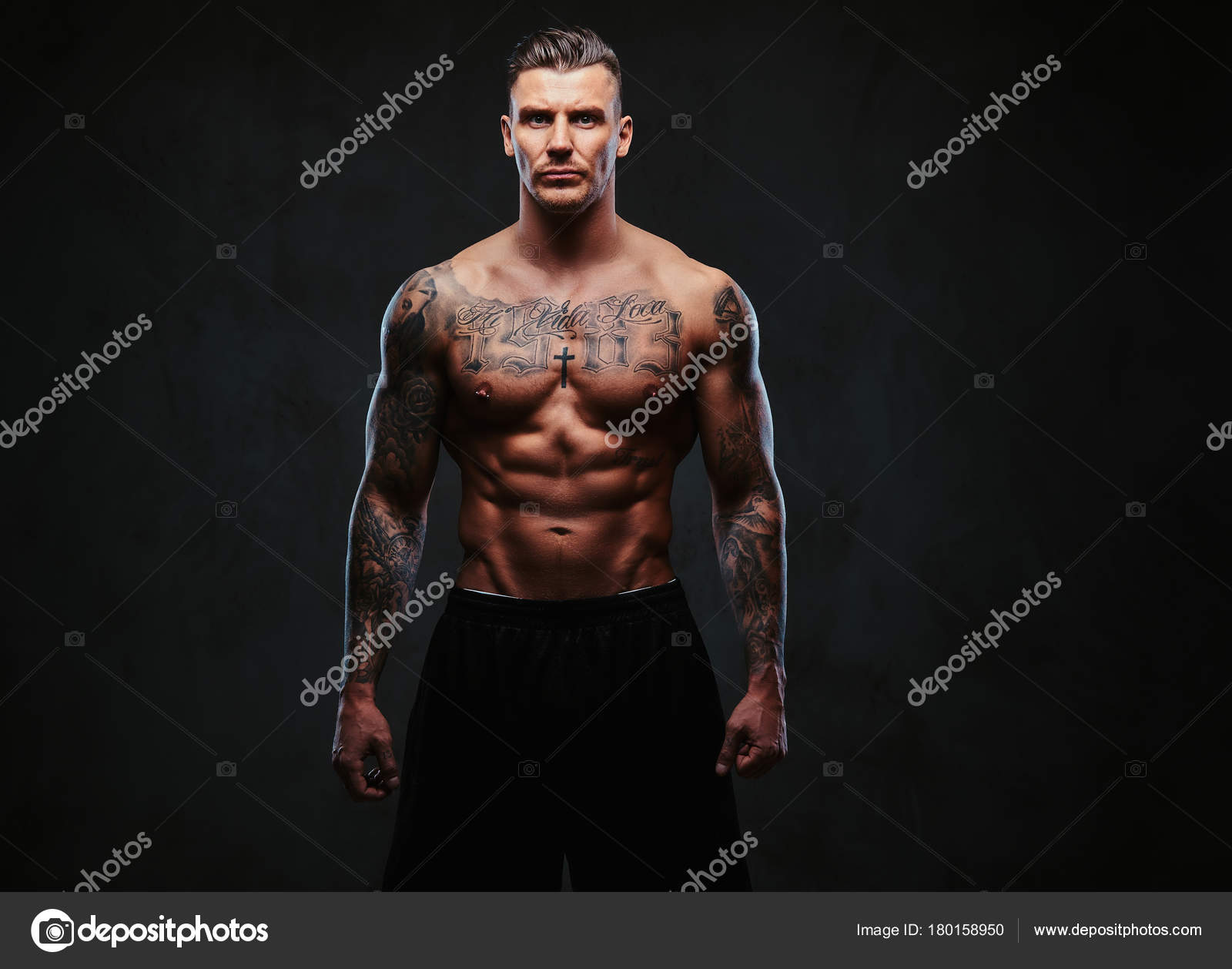 A muscular tattooed man on a dark background. — Stock Photo © fxquadro ...