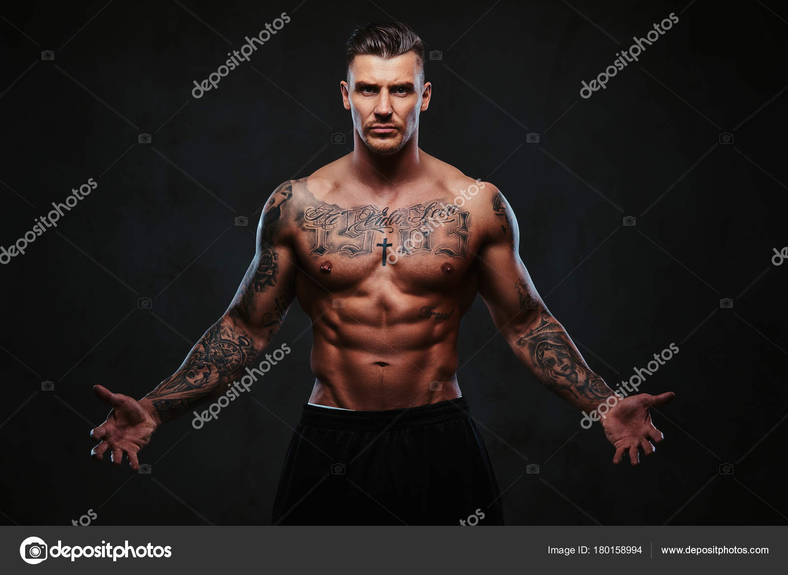 A muscular tattooed man on a dark background. Stock Photo by ©fxquadro ...