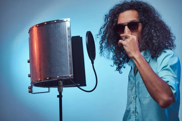 African vocal artist wearing a blue shirt emotionally writing song in ...