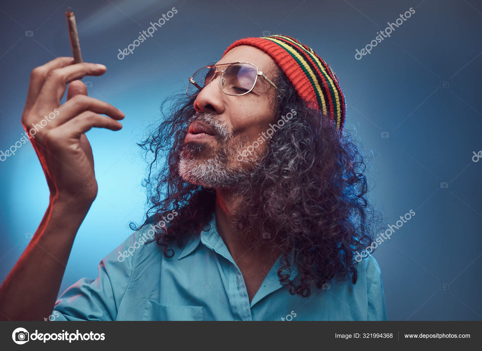 Studio portrait of African Rastafarian male smoking cigarettes — Stock ...