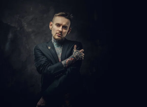 Modelo masculino tintado posando en un estudio oscuro con fondo gris ...