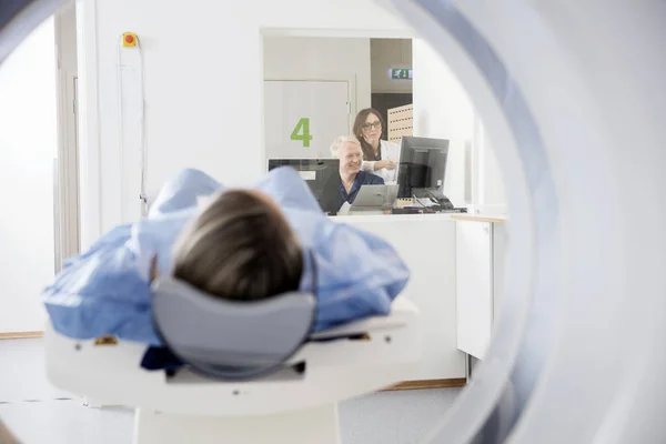 Doctors Using Computers While Patient Undergoing CT Scan - Stock Image ...