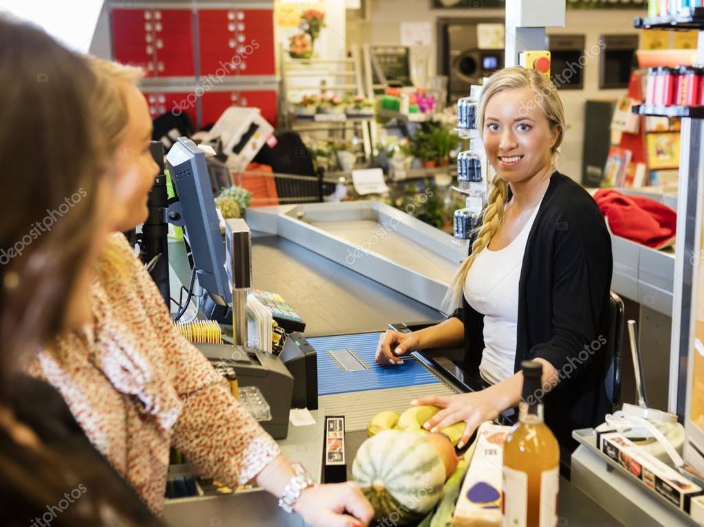 Cashier Smiling While Customers Standing At Checkout Counter — Stock ...